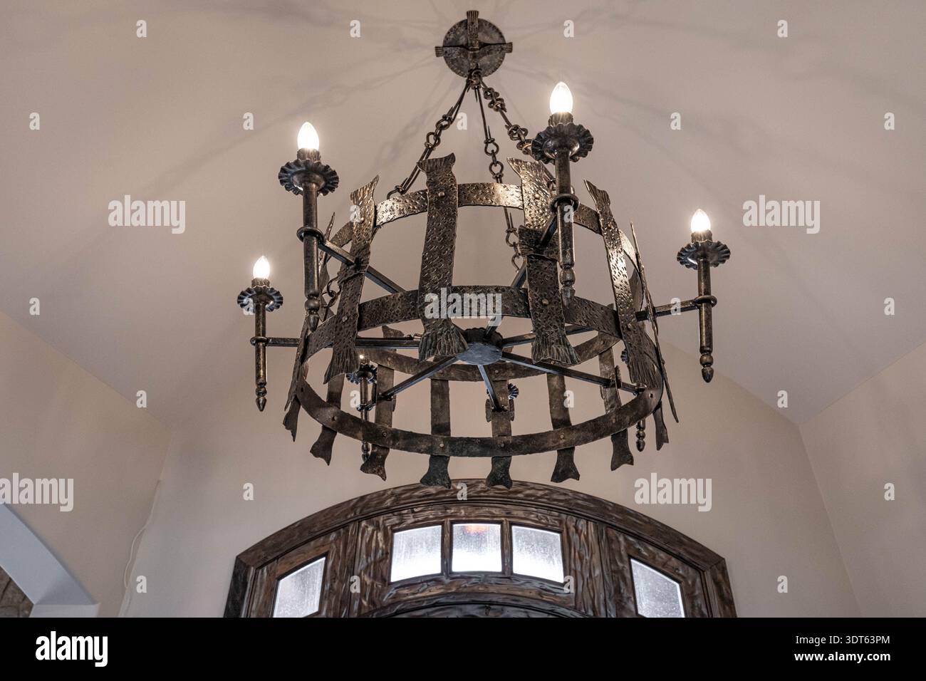 vintage medieval style chandlier hangs high above while it glows Stock ...