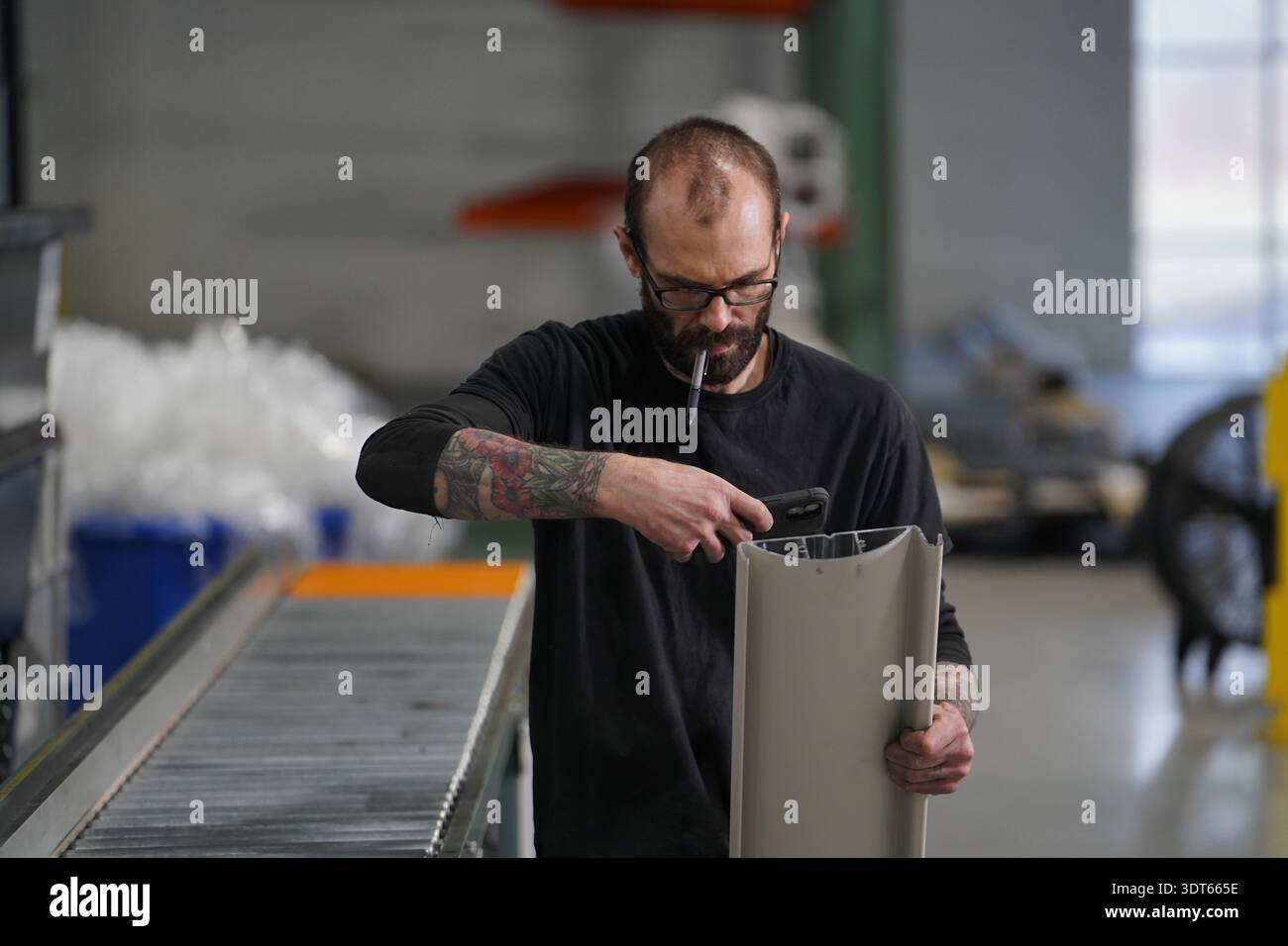 A worker photographs an aluminum beam on the factory floor at The ...
