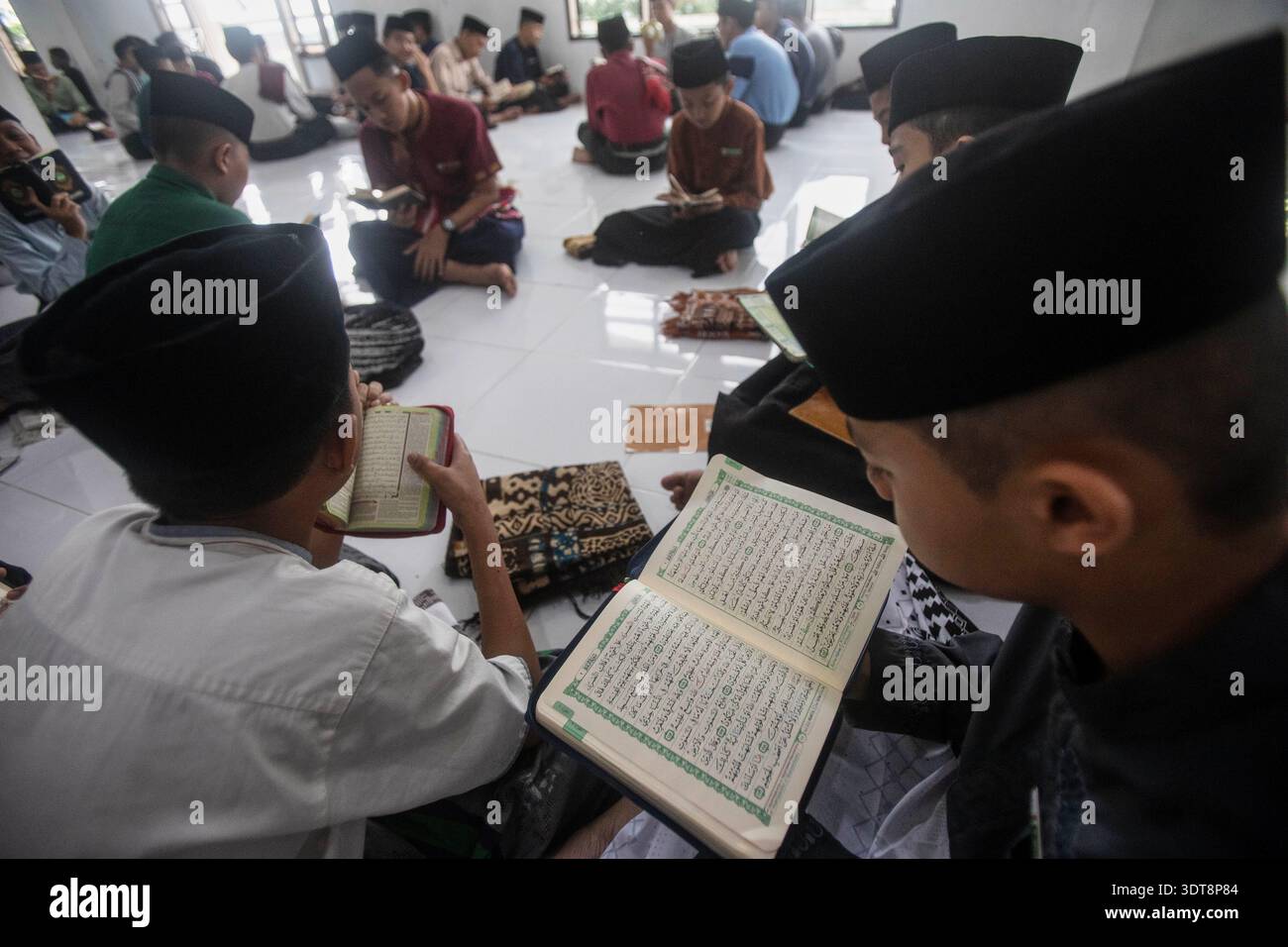 Students sit in circles as they read the Quran during the holy fasting ...