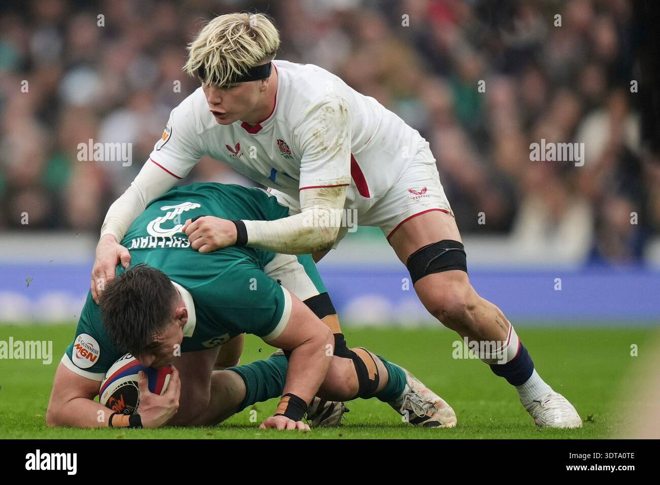 Ireland's Dan Sheehan, bottom, is tackled by England's Henry Pollock ...