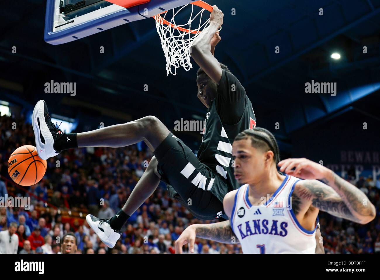 Cincinnati center Moustapha Thiam, top, dunks over Kansas guard Jayden ...