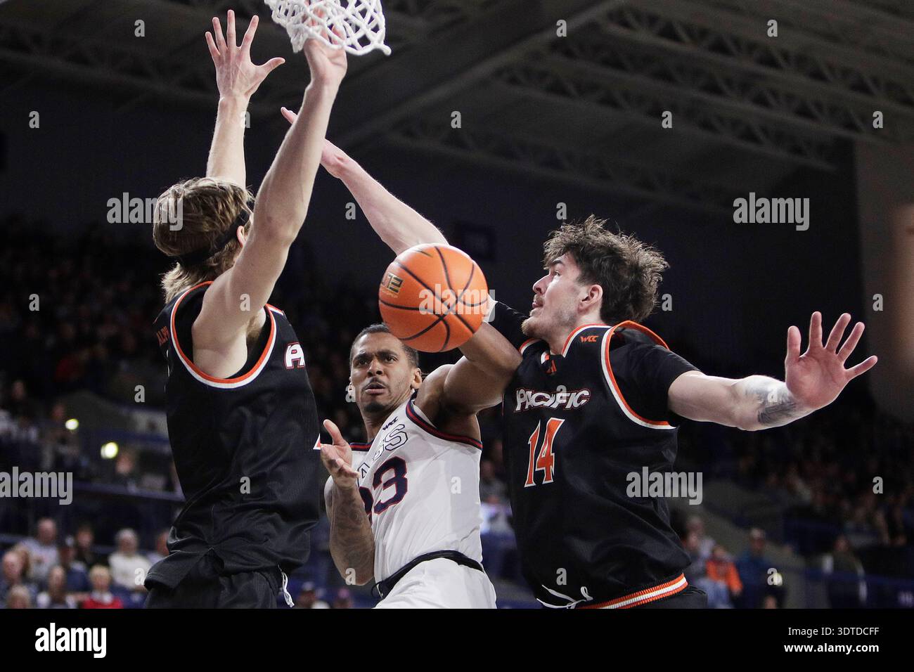 Gonzaga guard Adam Miller, center, passes the ball between Pacific ...