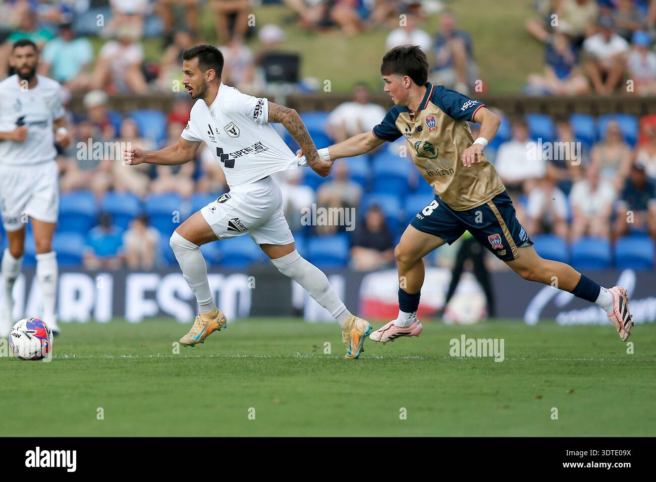 Sime Grzan of MacArthur FC is held by Lachlan Bayliss of the Jets ...