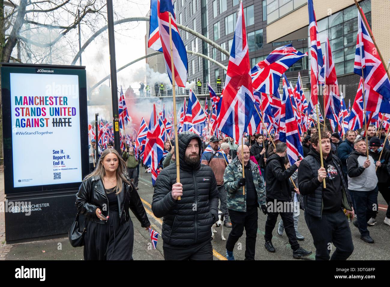 Manchester, UK. 21st Feb 2026. Britain first supporters march past a ...