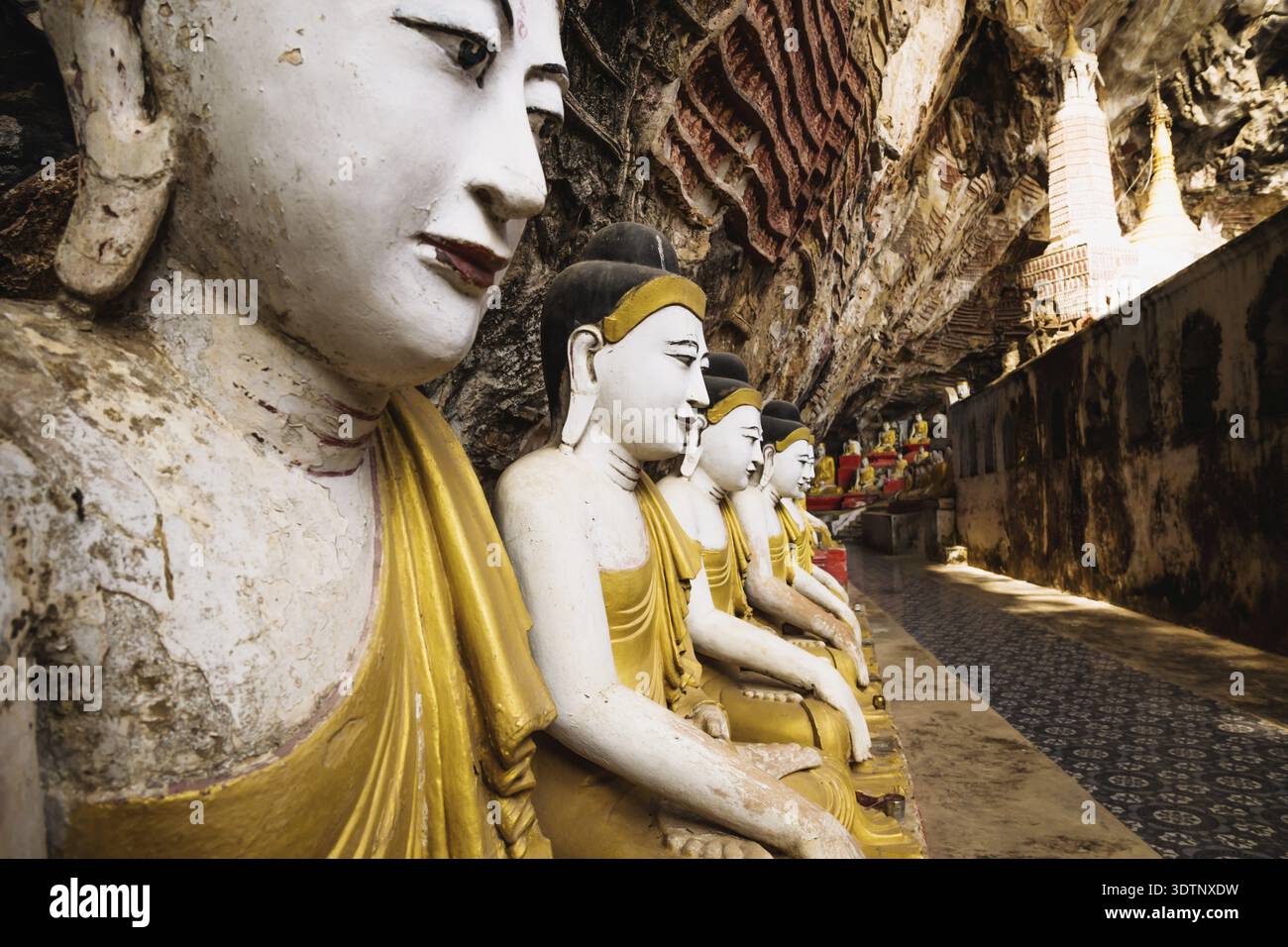 Ancient Buddha Statues In A Row Under Limestone Walls In Kawgun Cave