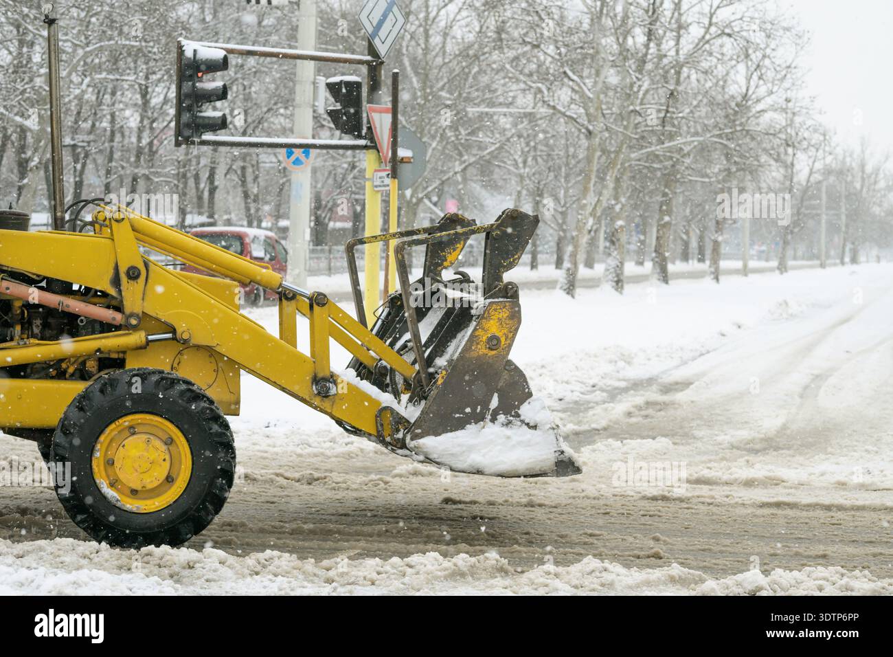 Snow removal loader clears heavy snow and slush from a city road during ...