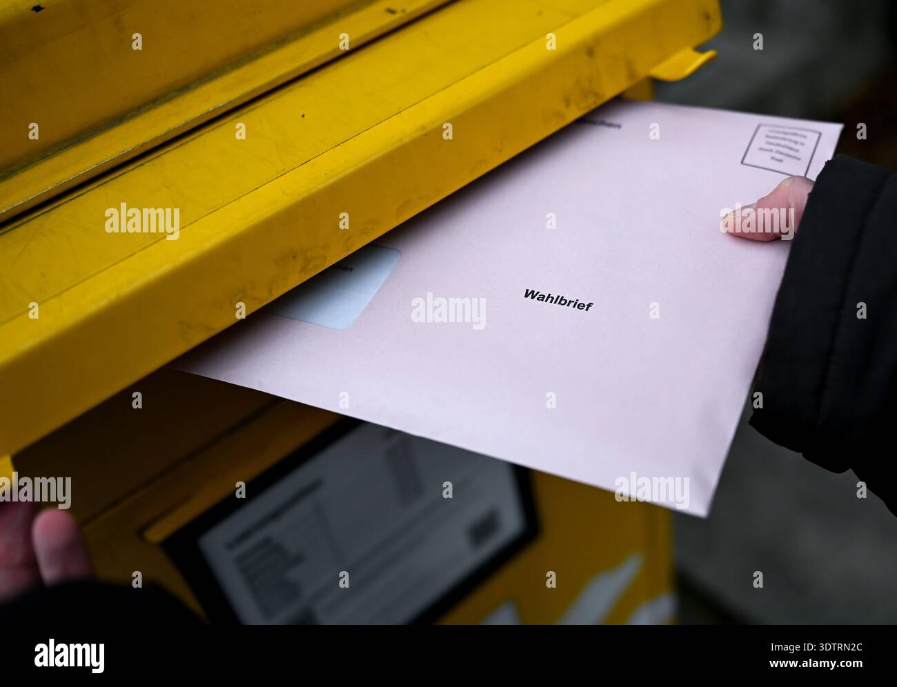 23 February 2026, Bavaria, Munich: A woman drops an election letter for ...