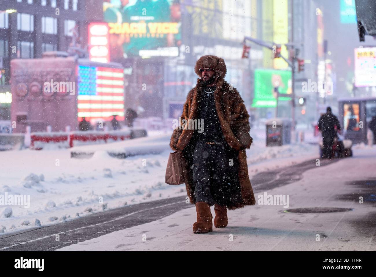 A man walks through Times Square during a snow storm, Monday, Feb. 23 ...