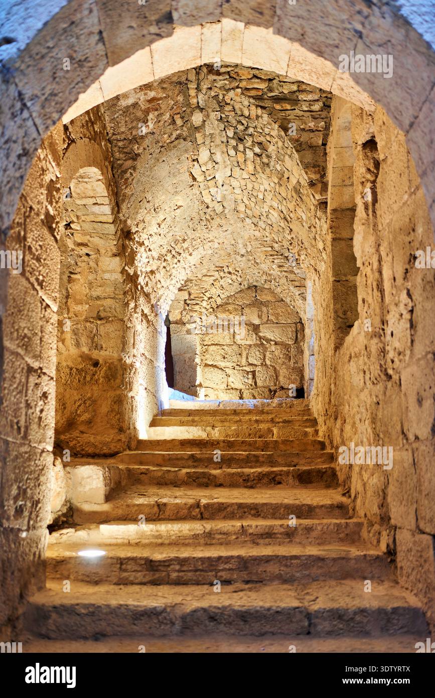 Visitors walk up the stone steps in Ajloun Castle, a historic site in ...