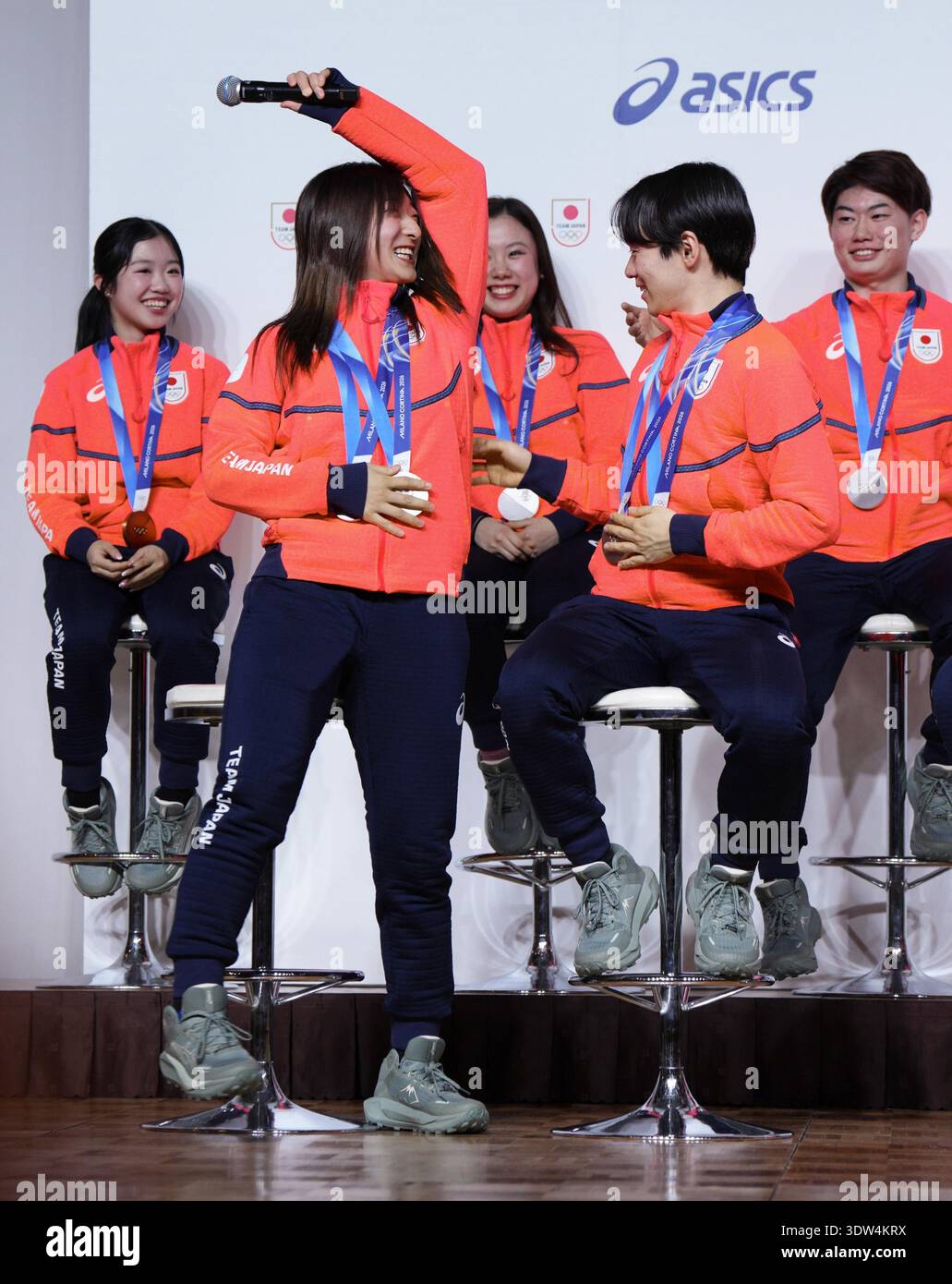 Japan's Kaori Sakamoto (L, front row) hands the microphone to athletes ...