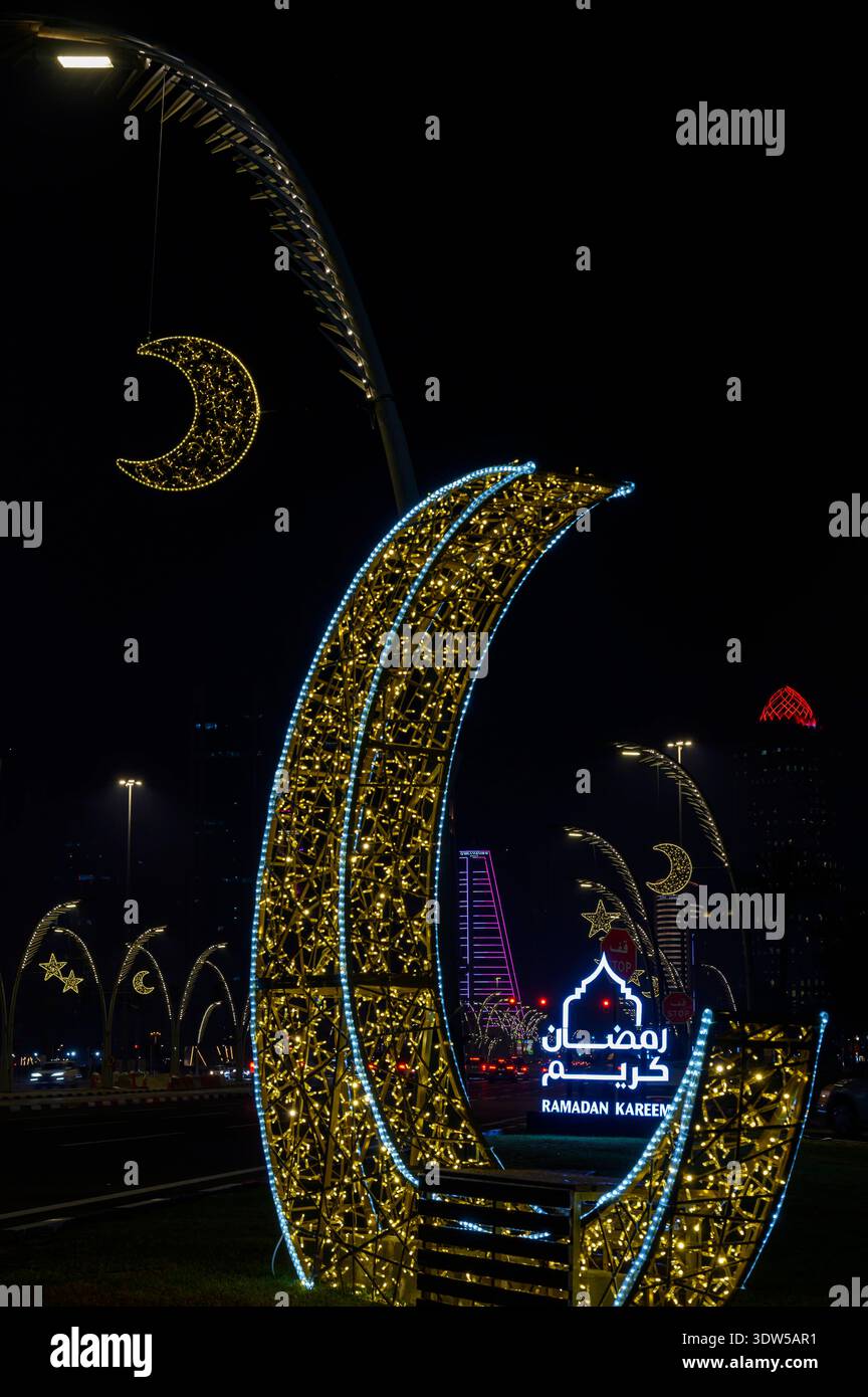 Ramadan lighting in Doha street. Vehicles drive along a road decorated ...