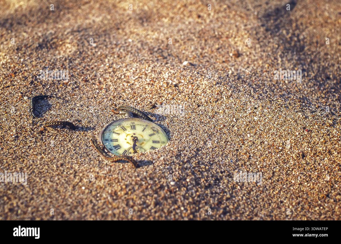 Antique rotten pocket watch buried partial in the sand Stock Photo - Alamy