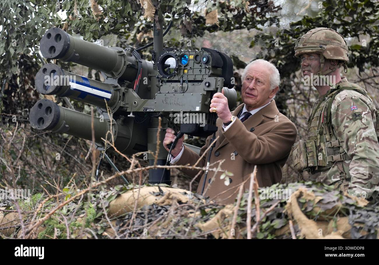 King Charles III looks at a lightweight multiple launcher during a ...