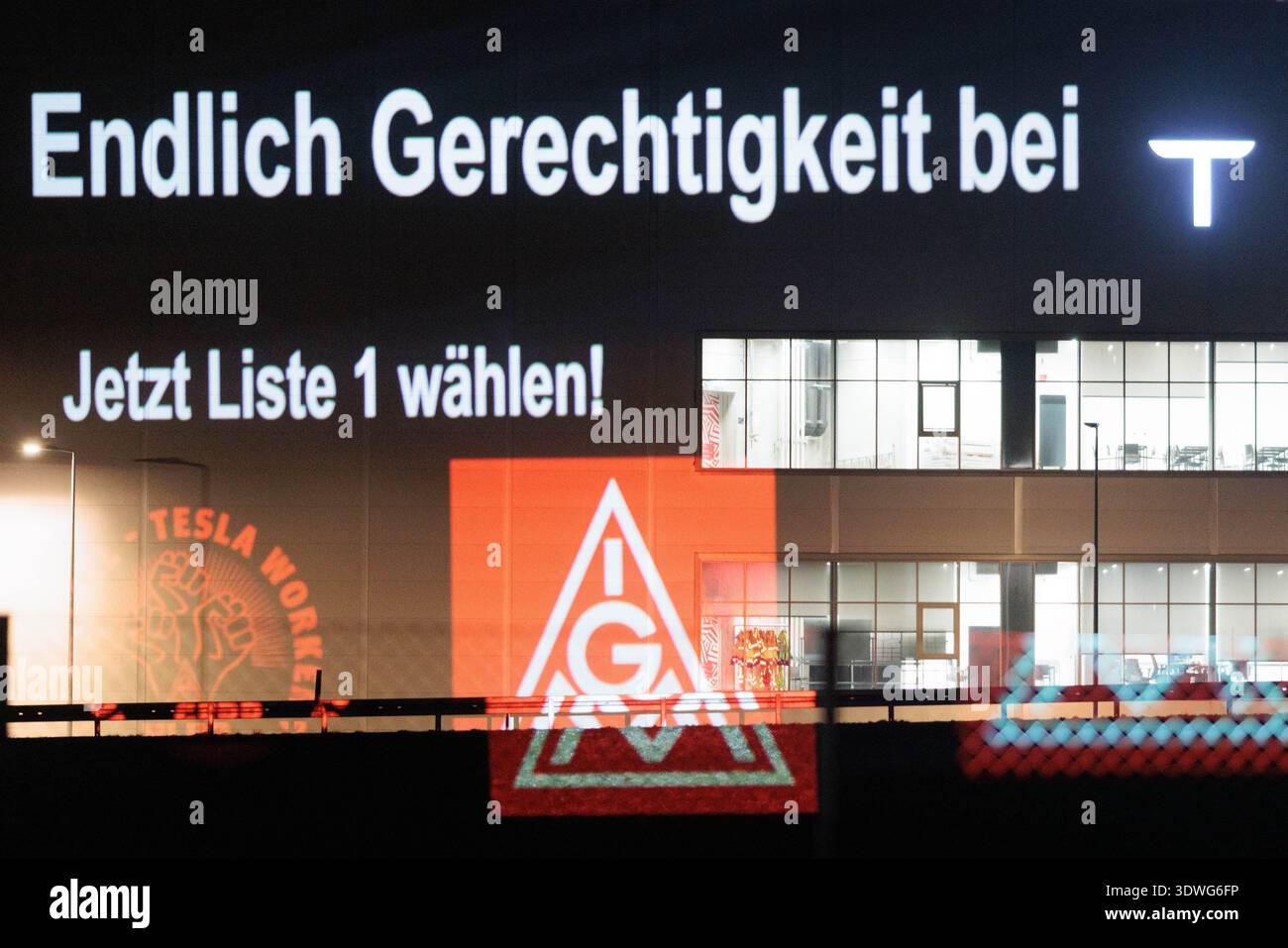 26 February 2026, Brandenburg, Grünheide: Members of IG Metall light up ...