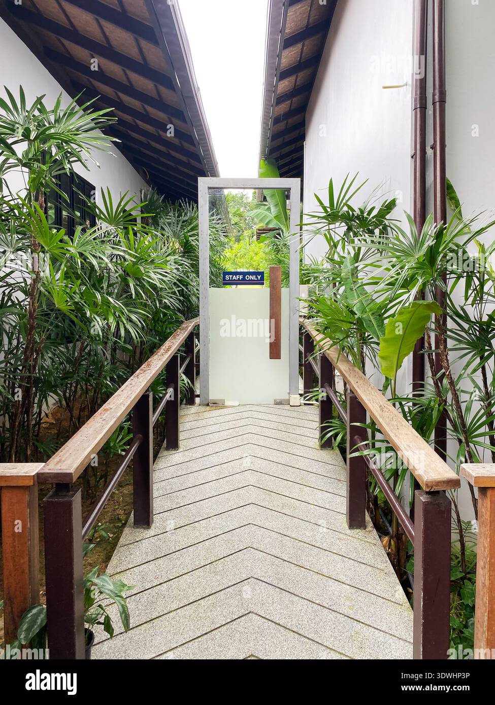 Pathway with a wooden railing leads to a white door labeled 'Staff Only ...