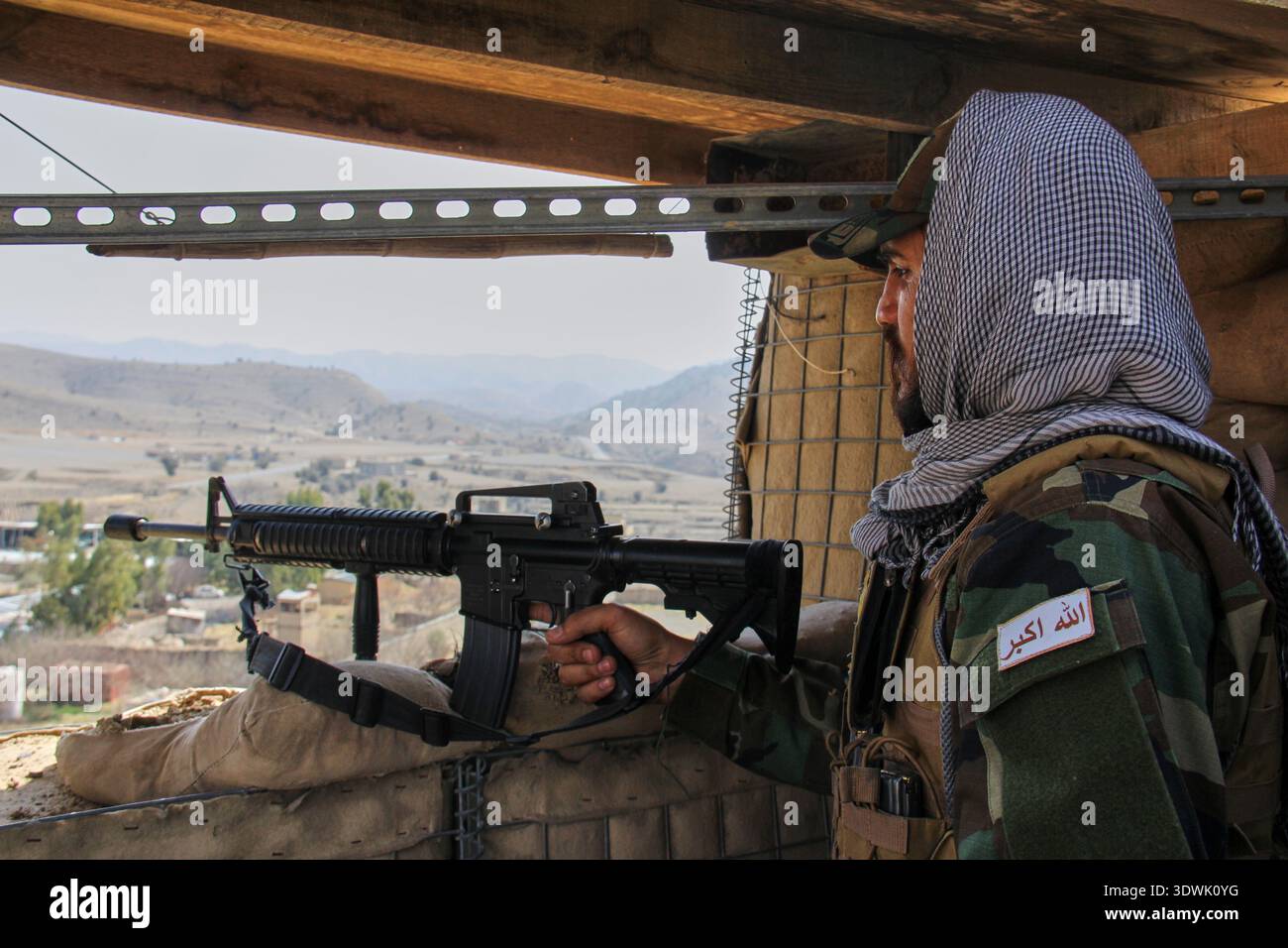 A Taliban soldier stands guard at a military checkpoint at the Afghan ...