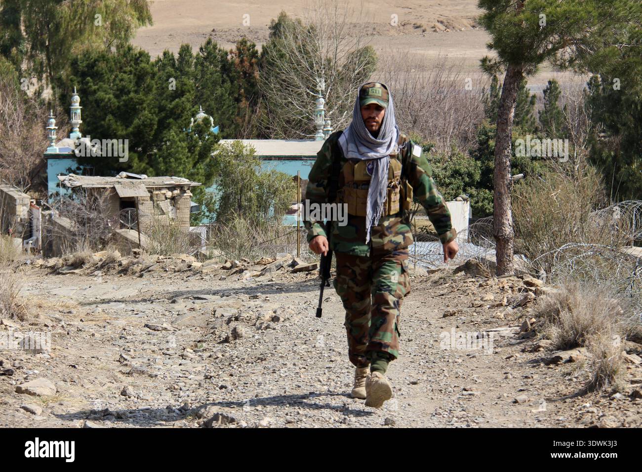 A Taliban soldier patrols the area at a military checkpoint at the ...