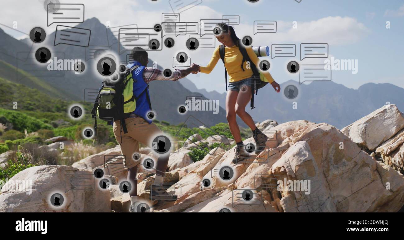 Helping woman hiker in yellow longsleeve top pulling partner up rocky ...