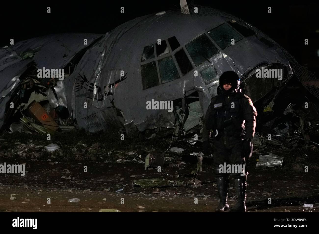 A military police stands next to a plane that crashed in El Alto ...