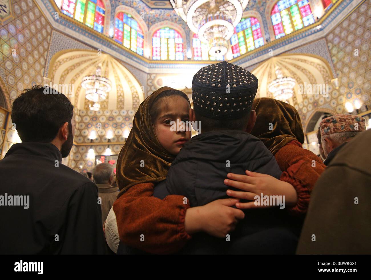 A man carries his daughters after attending Friday congregational ...