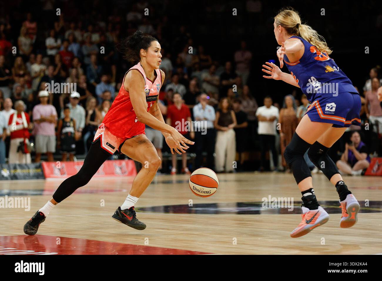 Ally Wilson of Perth Lynx drives past Jessie Edwards of the Townsville ...
