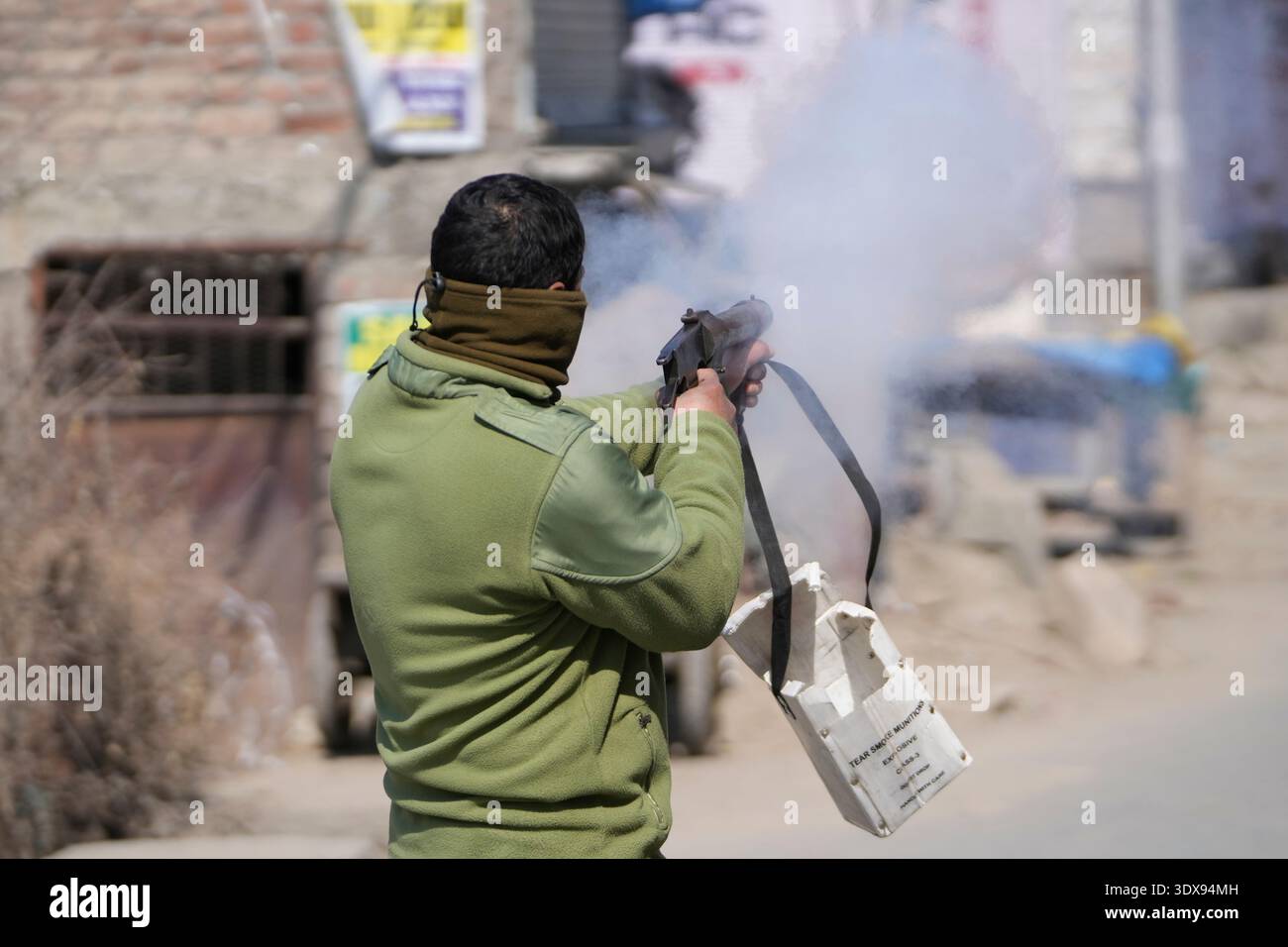 Indian police man fires tear gas shell towards Shiite Muslim during a ...