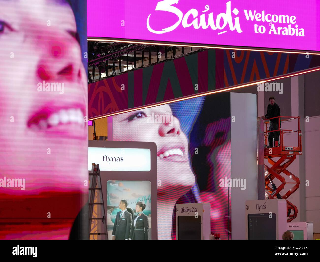 02 March 2026, Berlin: A stand builder works at the Saudi Arabian stand ...