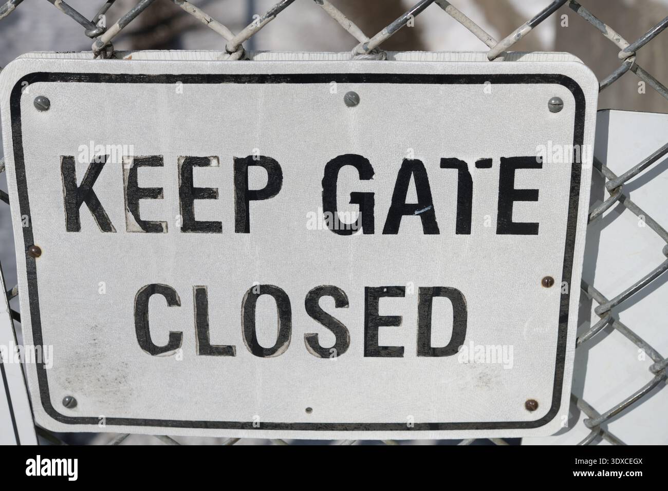 old metal sign with keep gate closed message fixed to a chain link ...