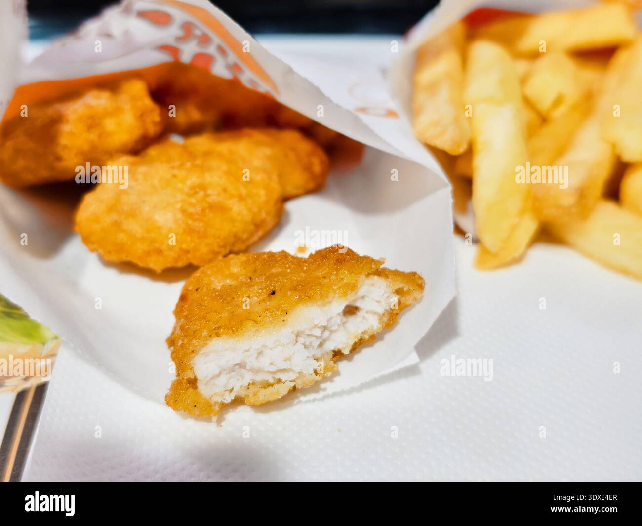 Crispy fried chicken nuggets served with golden French fries in a ...