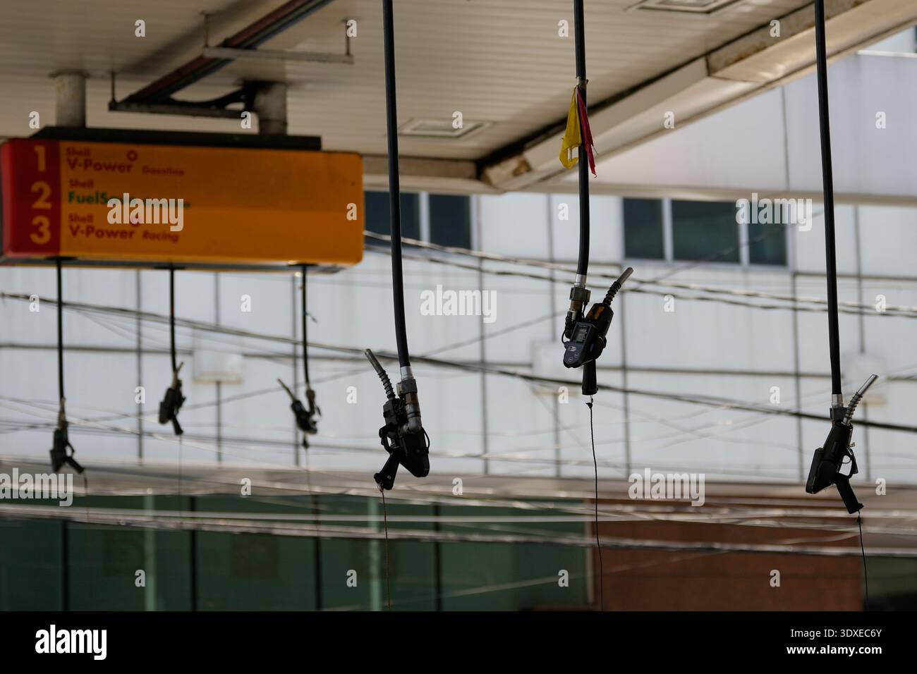 Hanging fuel nozzles are seen at a gasoline station in Manila ...