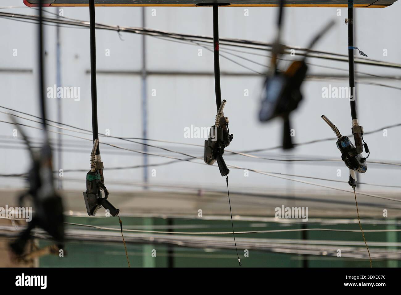 Hanging fuel nozzles are seen at a gasoline station in Manila ...