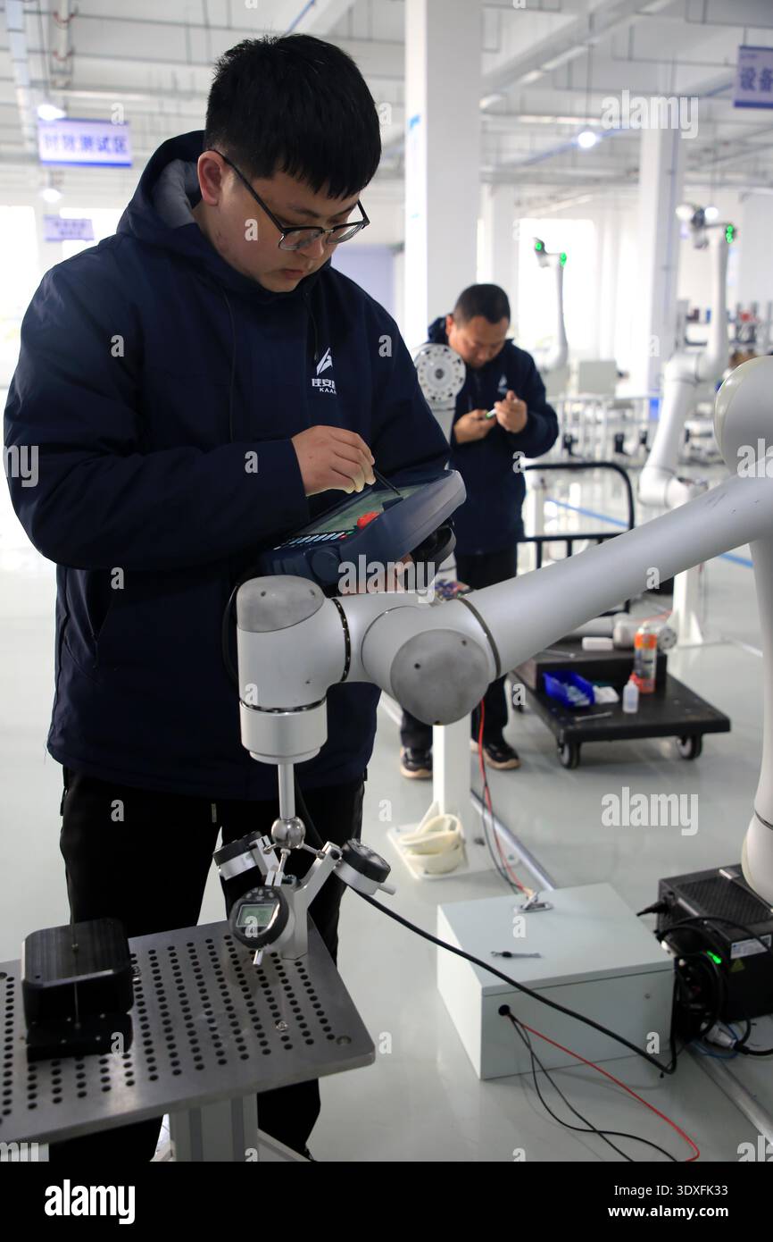 Technicians test collaborative robotic arms at a robot technology ...