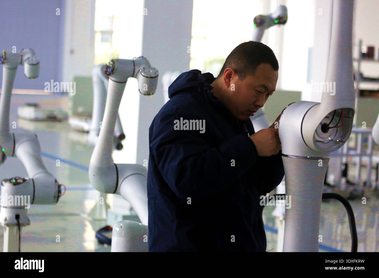 Technicians test collaborative robotic arms at a robot technology ...