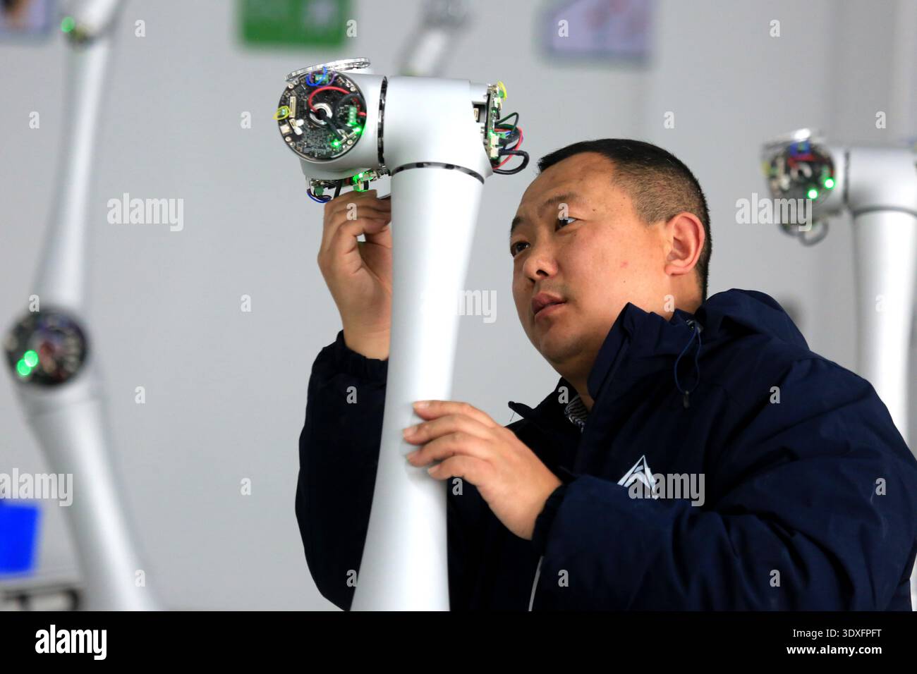 Technicians test collaborative robotic arms at a robot technology ...