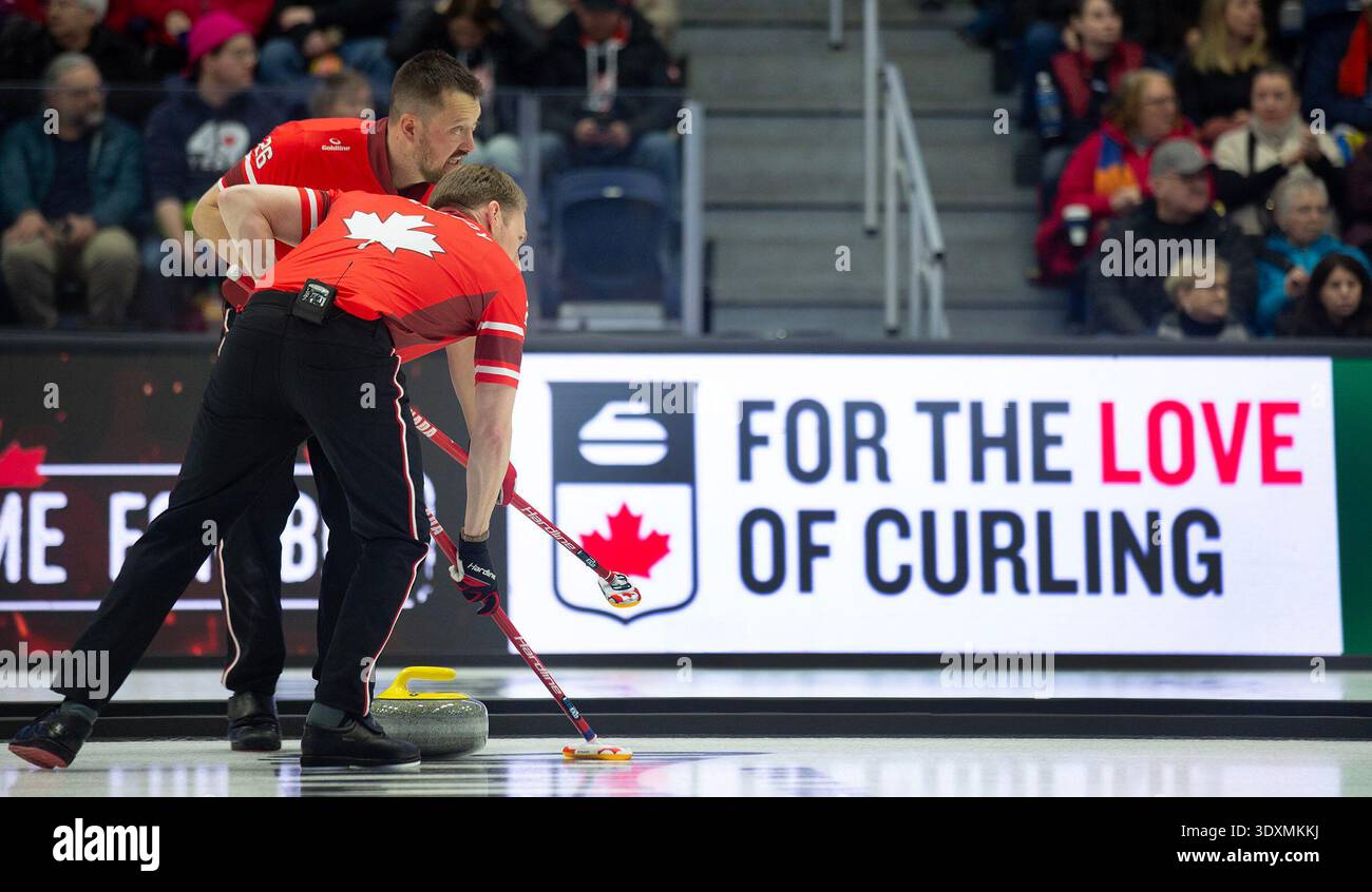 Ben Hebert and Marc Kennedy of Team Canada sweep a stone during Draw 11 ...