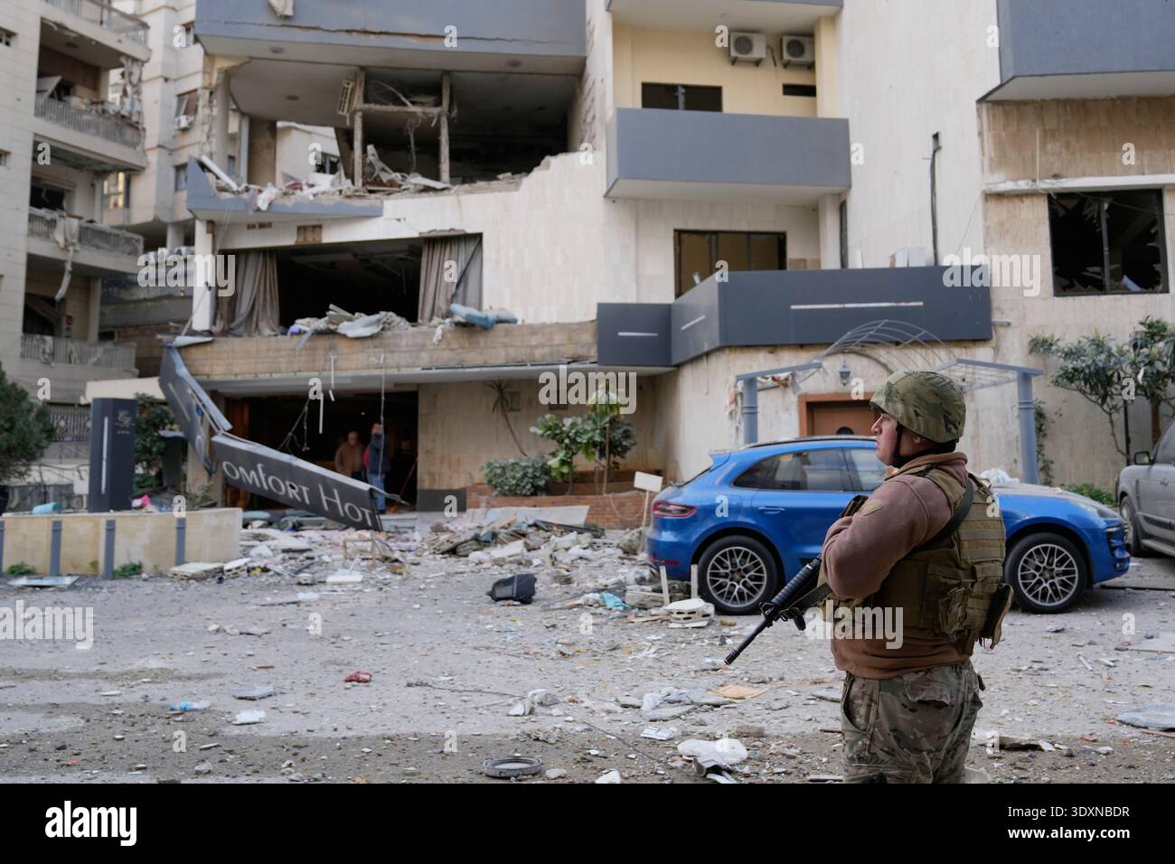 A Lebanese soldier stands in front of a damaged hotel that was hit by ...