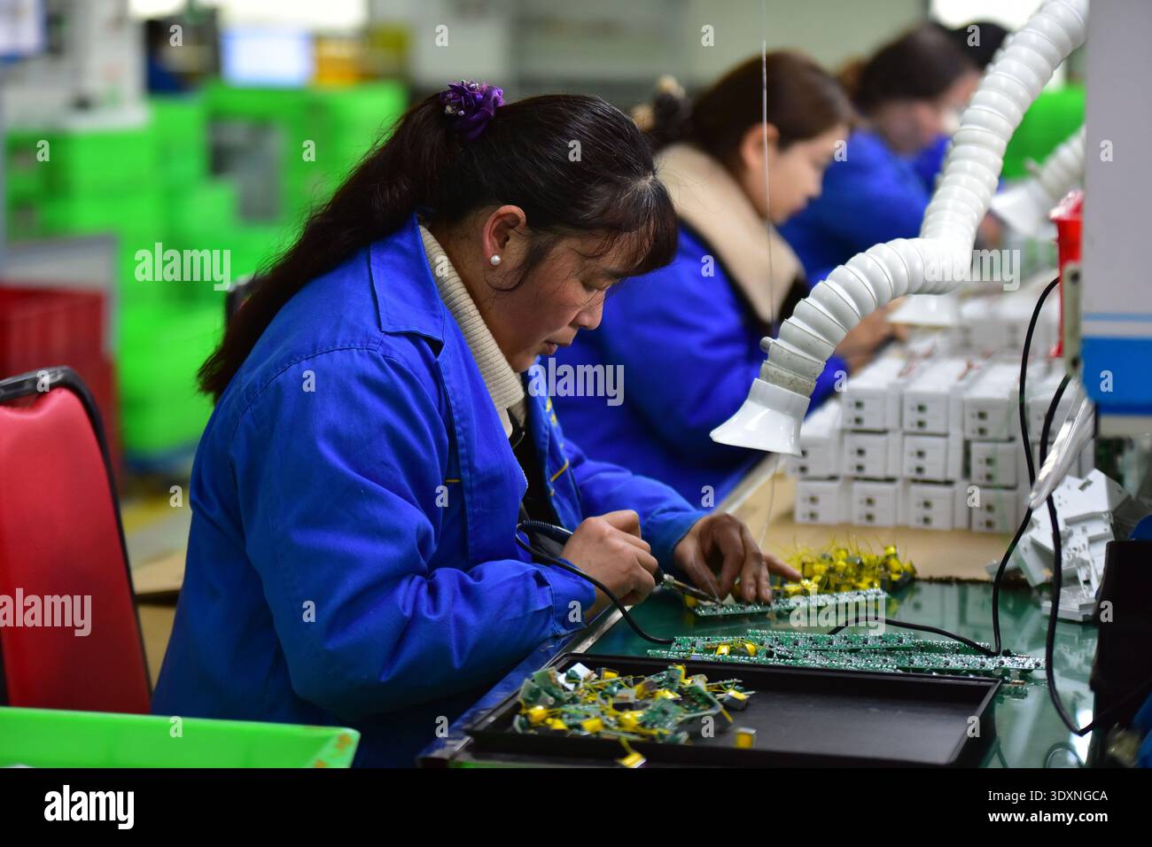 Women assemble circuit breakers at a manufacturer of electrical ...