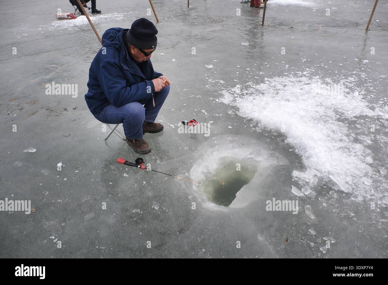 Winter fishing enthusiasts enjoy ice fishing on the frozen lake at ...