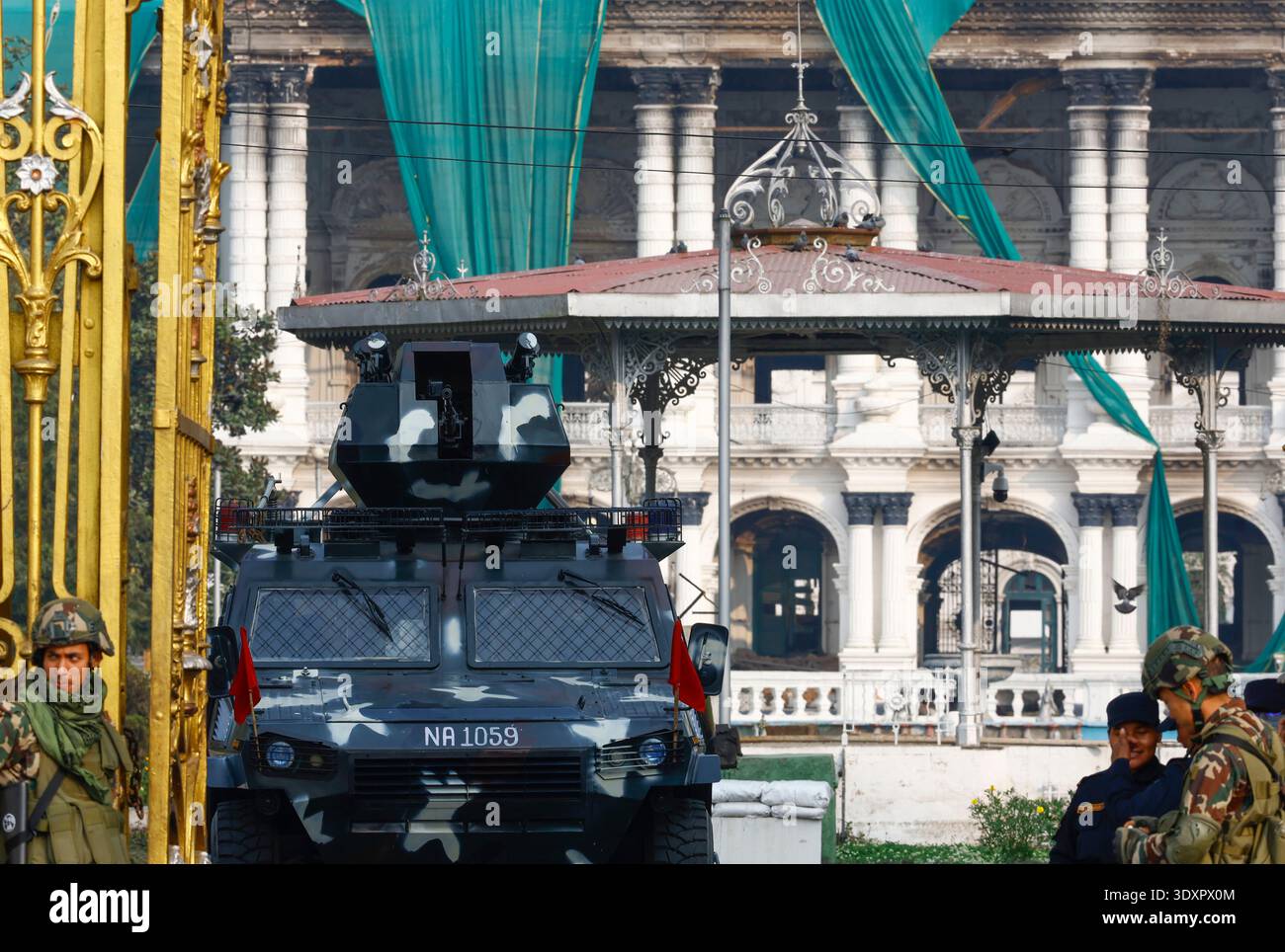 An army personnel stands guard inside an armored personnel carrier ...