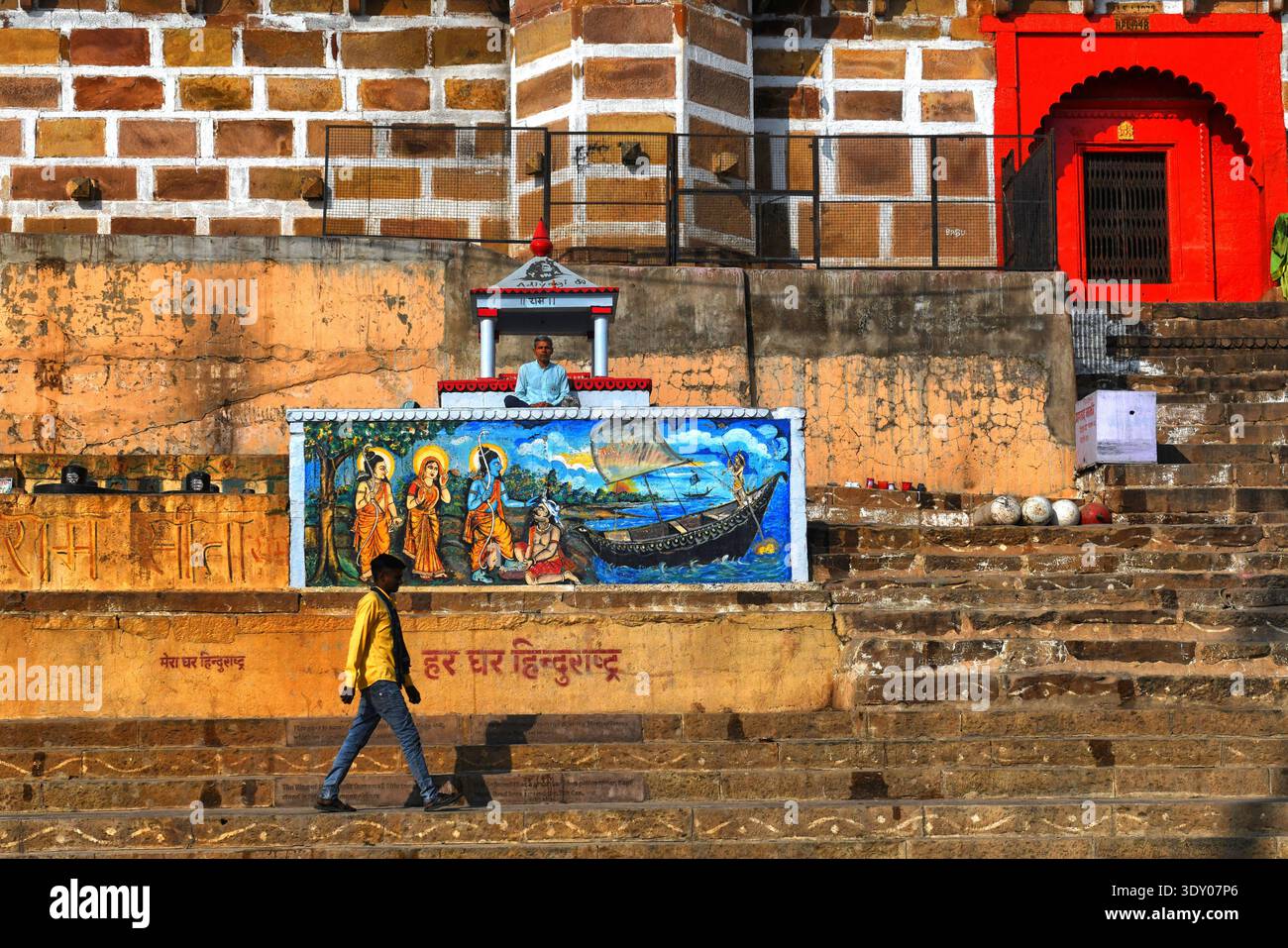 A priest offers prayer to Lord Sun seating on the stairs of a riverside ...