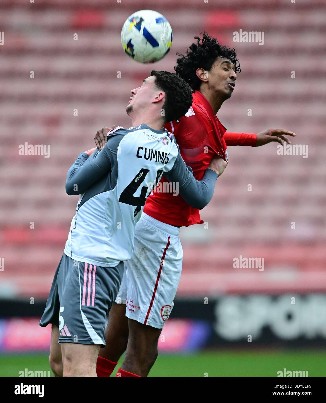 Barnsley's Vimal Yoganathan has an aerial challenge with Exeter City's ...