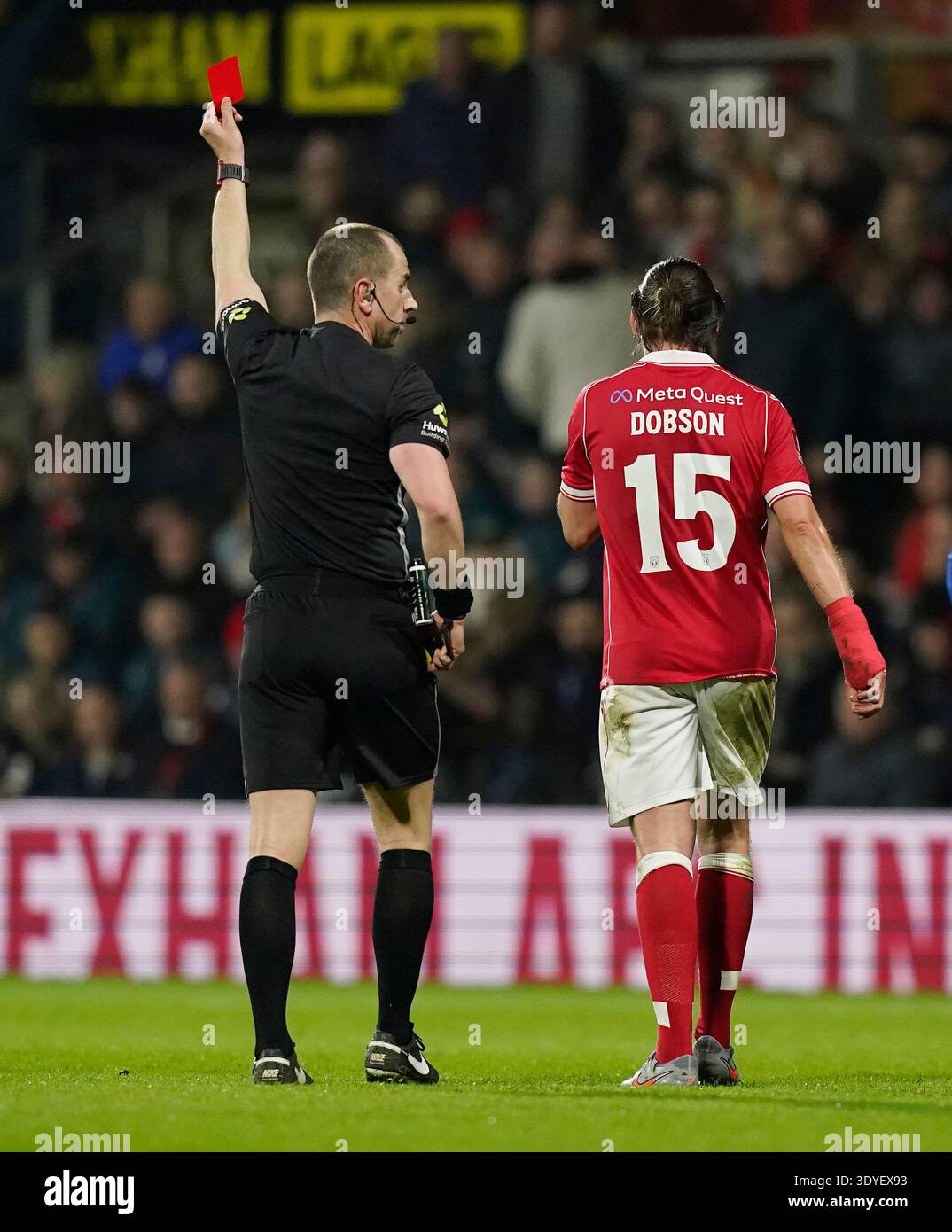 Wrexham, Wales, 7th March 2026. Wrexham’s George Dobson is shown a red ...