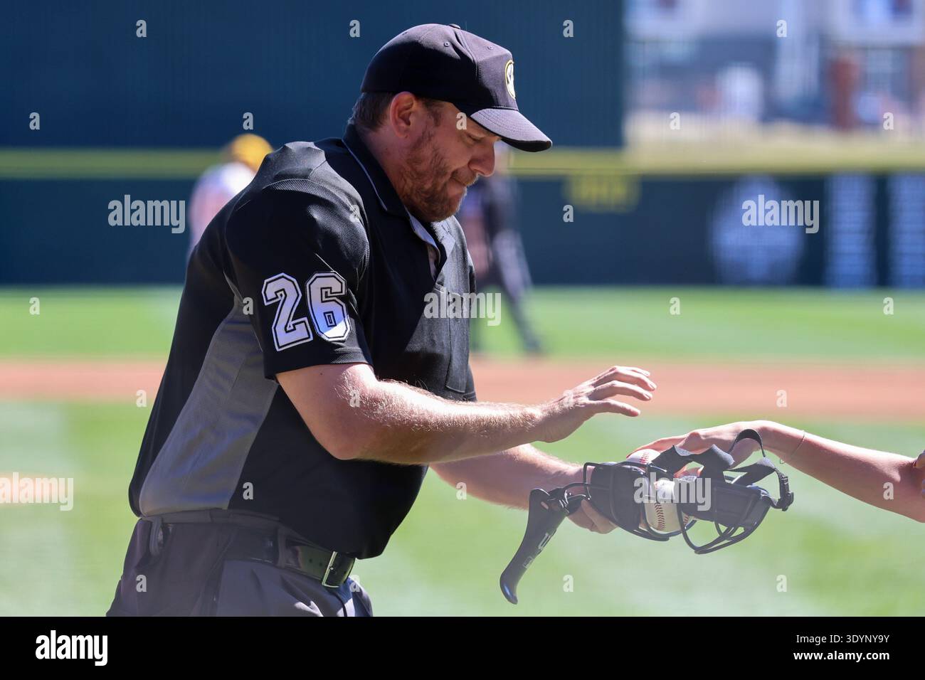 March 8, 2026: Home plate umpire Ronnie Teague holds out his mask to ...