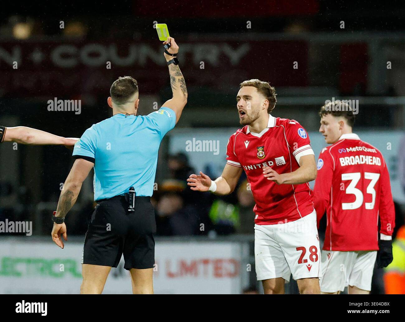 Wrexham's Sam Smith is shown a yellow card by referee Stephen Martin ...