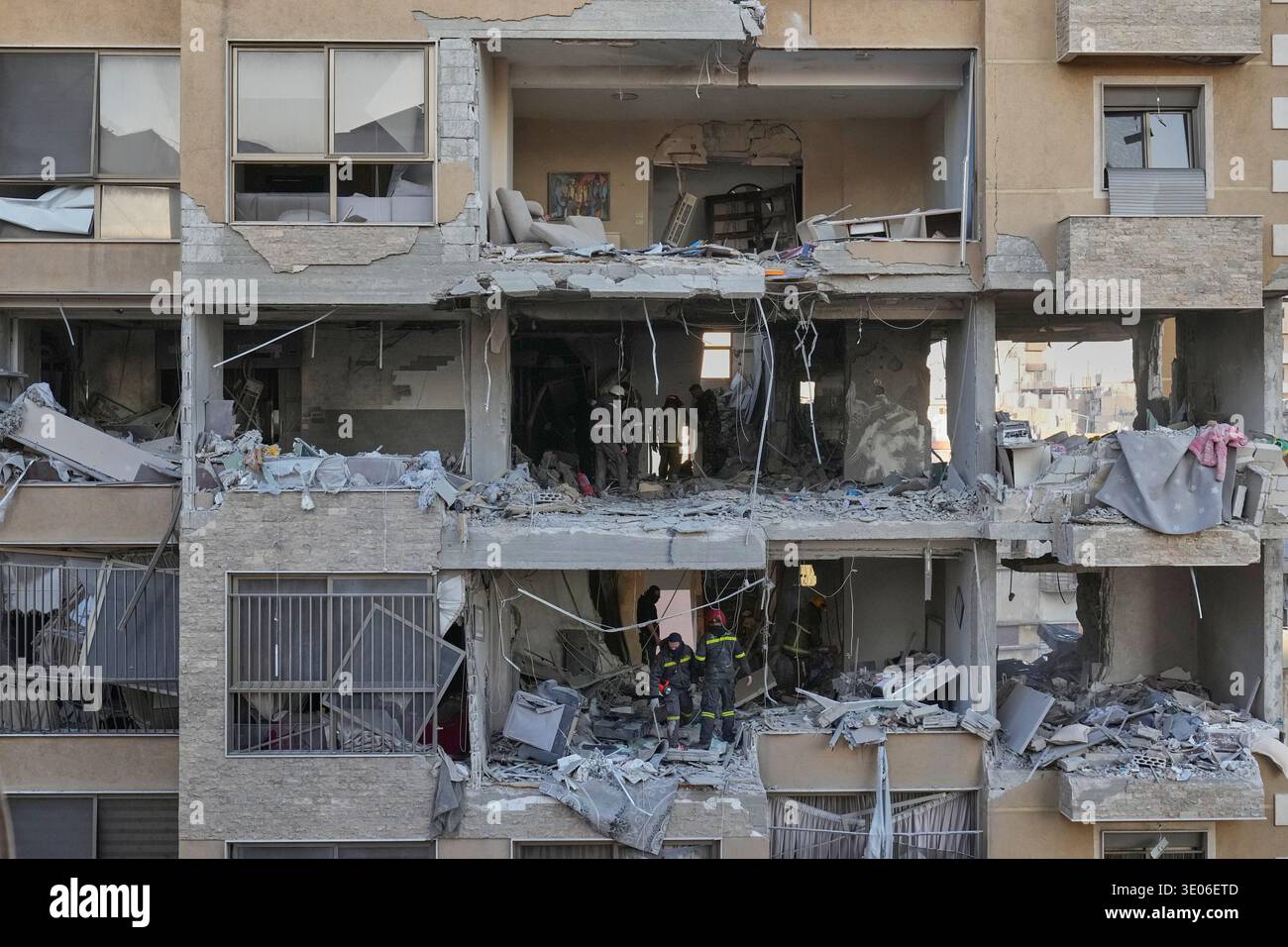 Rescue workers check destroyed apartments that were hit by Israeli ...