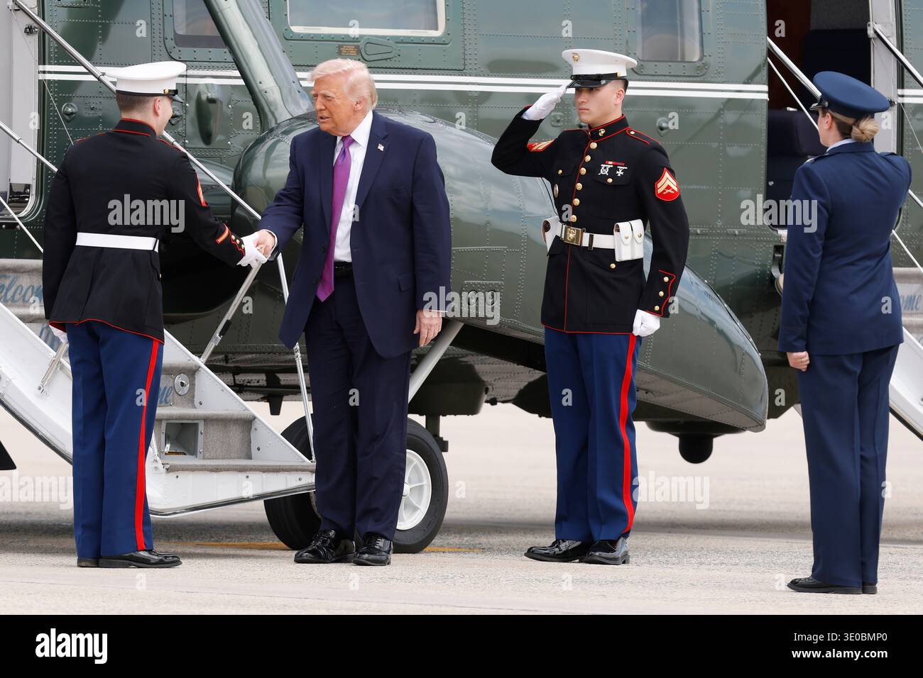 President Donald Trump, center, gives a Marine One crew chief, left, a ...