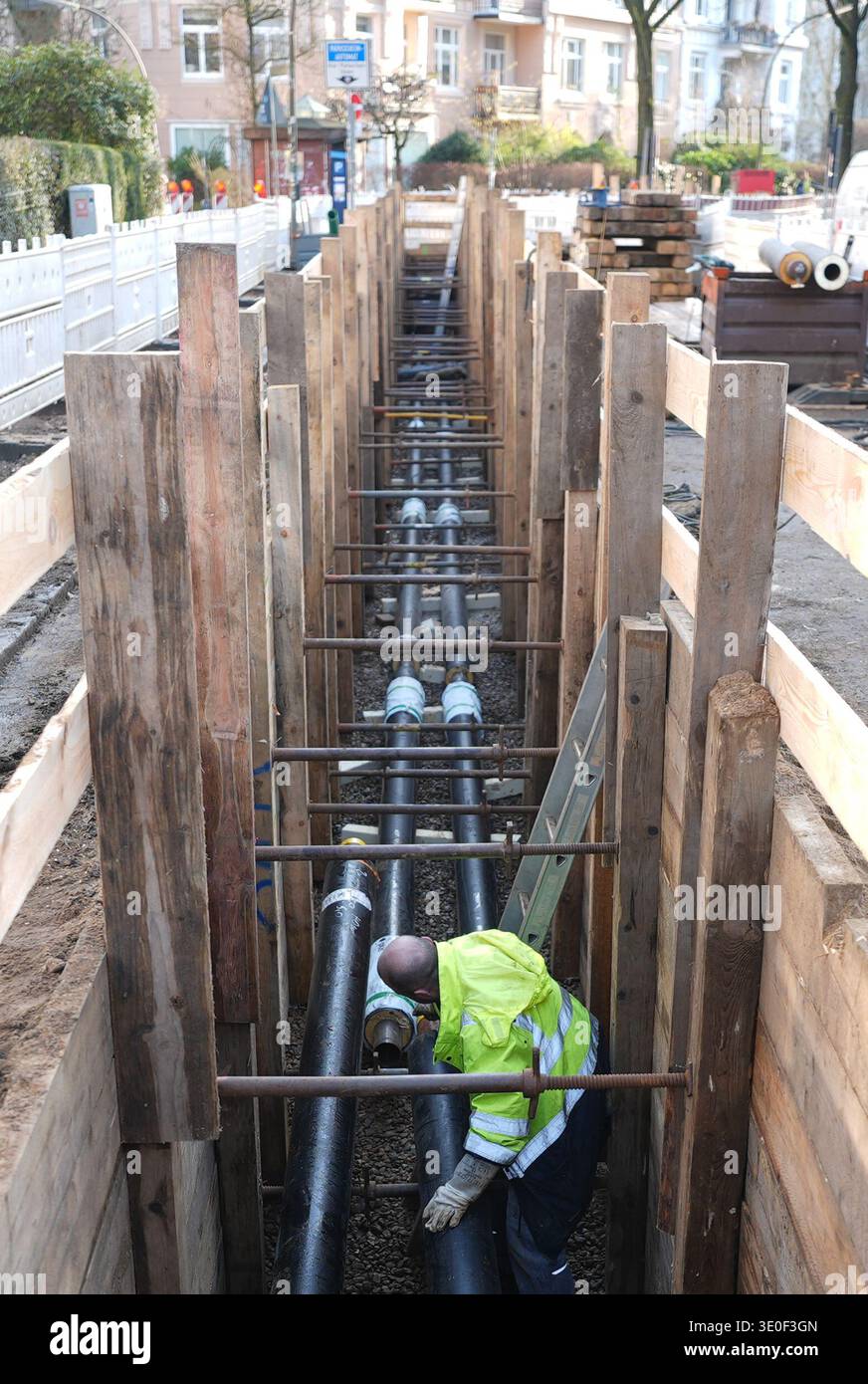 02 March 2026, Hamburg: Workers lay pipes for district heating at a ...