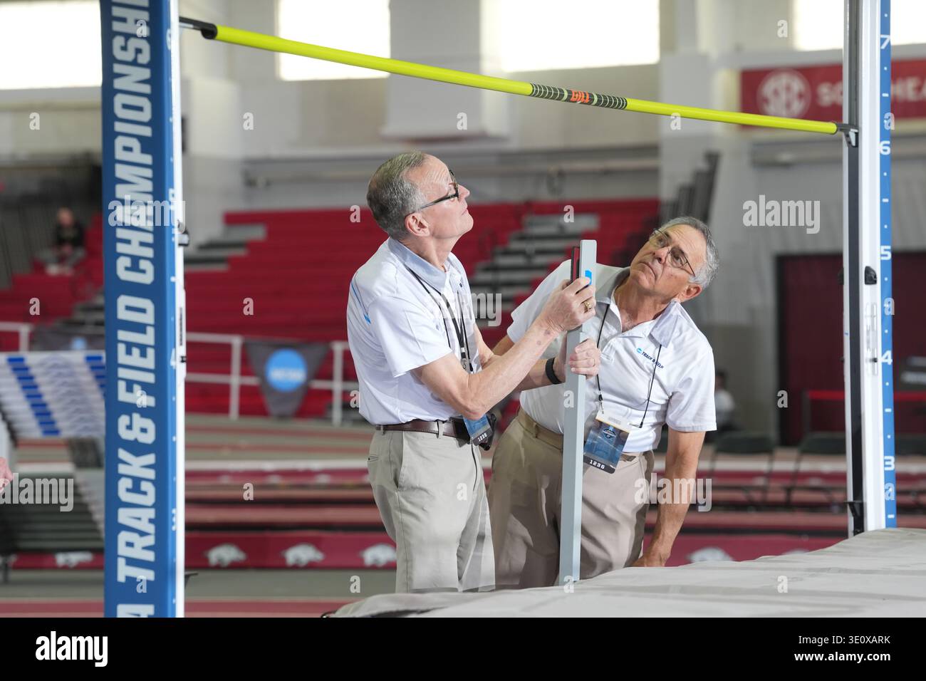Officials measure the height of the crossbar in the pentathlon high ...