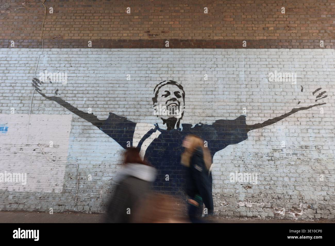 Fans walk past a mural of Neil Harris outside Millwall Football Club ...