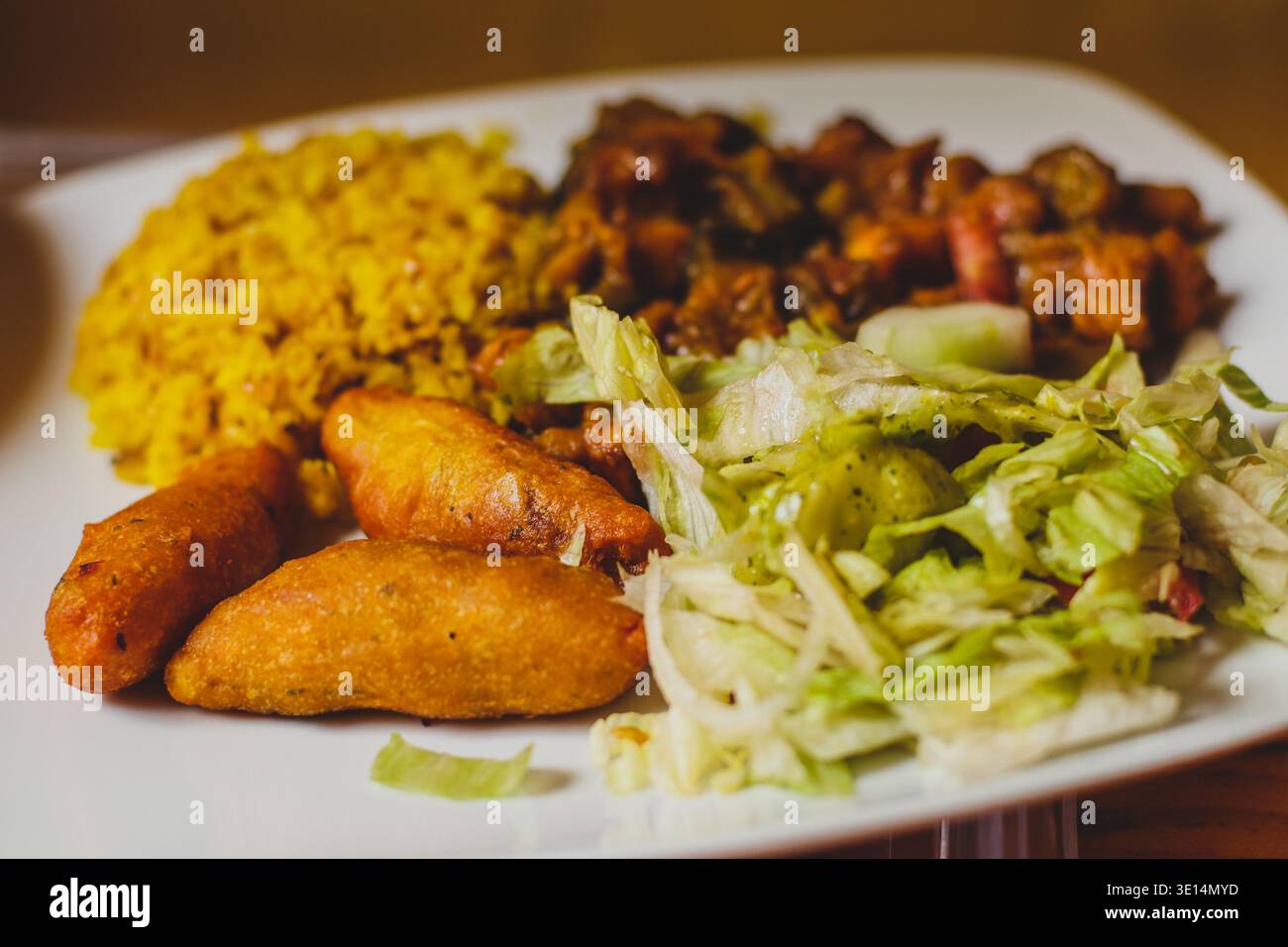 A traditional Colombian plate features golden yellow rice, crispy fried ...